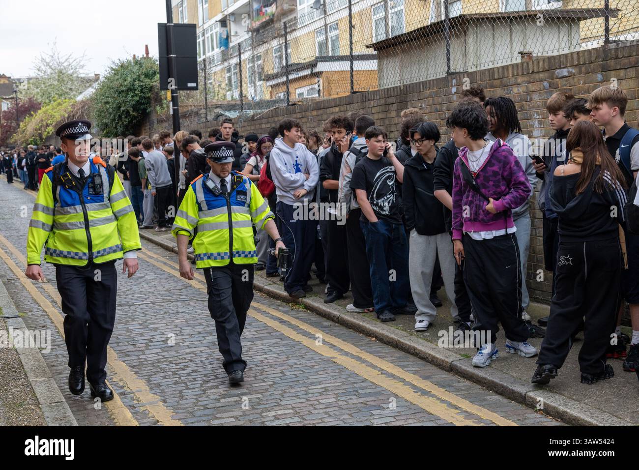 19/04/2025. London, UK Police officers monitor hundreds of teenagers queue in Shoreditch to ...