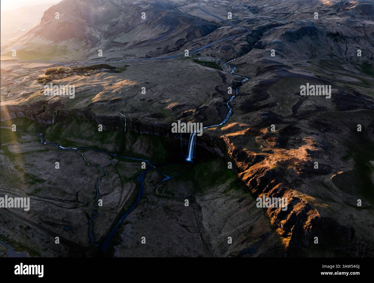 Aerial view of Seljalandsfoss waterfall plunging from a cliff into ...