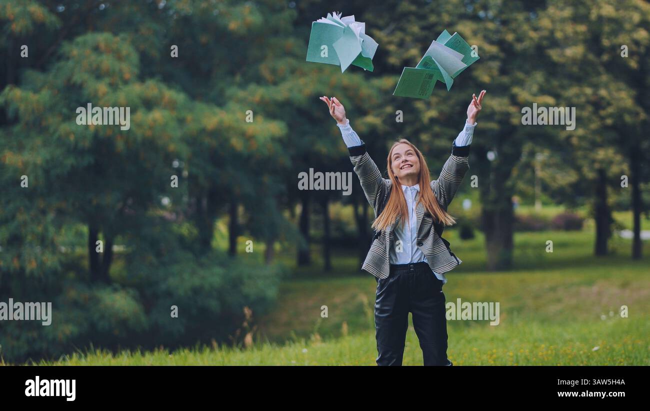 Excited student throwing books up in the air celebrating end of school ...