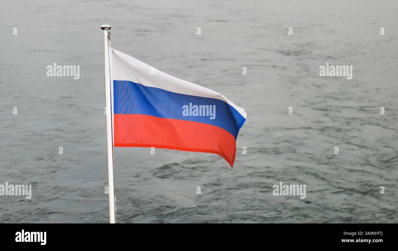 Russian flag waving vibrantly above rippling water, embodying national ...