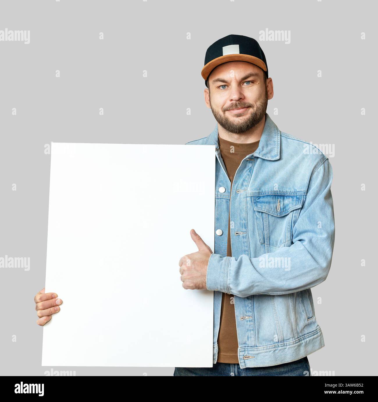 mockup isolated young adult man in denim jacket and cap holding white ...