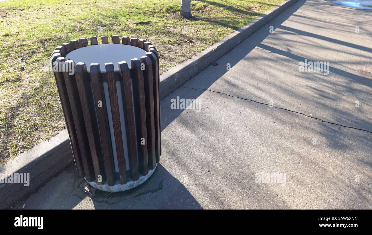 Empty wooden trash bin near park path in sunlight Stock Photo - Alamy
