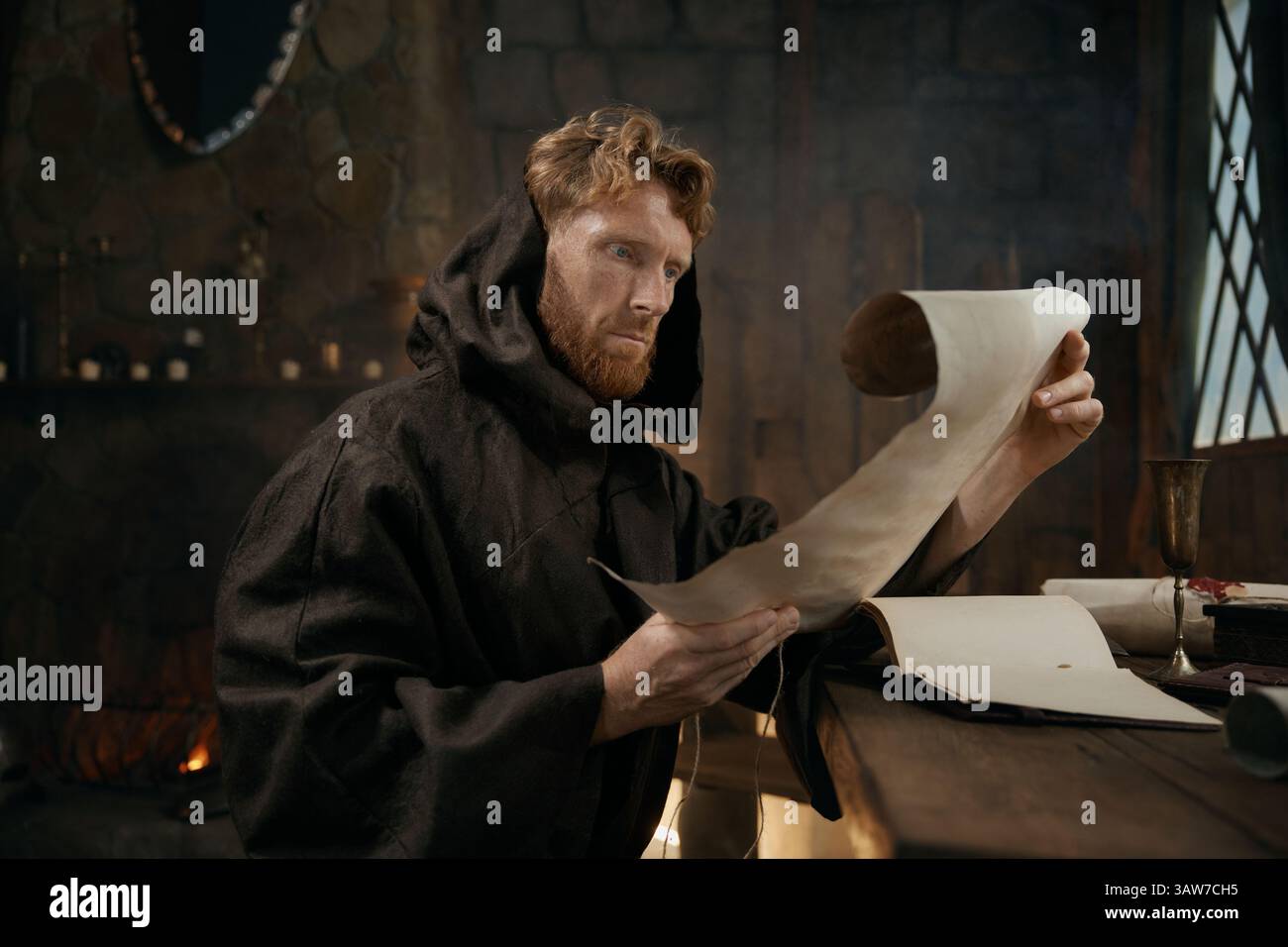 Medieval monk wearing robe with hood reading sacred manuscript on ...