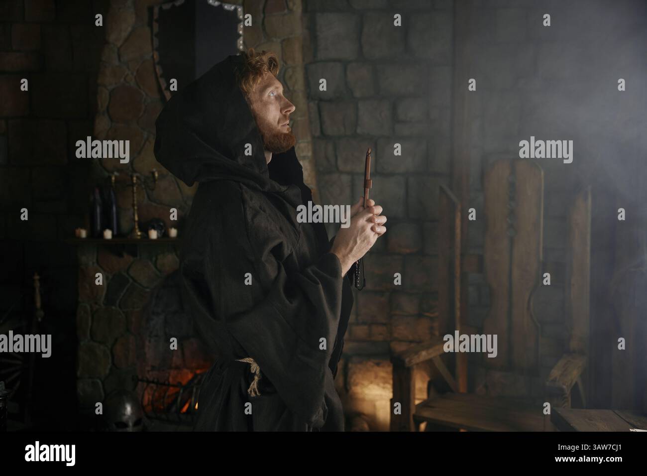 Faithful priest in robe hood praying with rosary beads and cross Stock ...