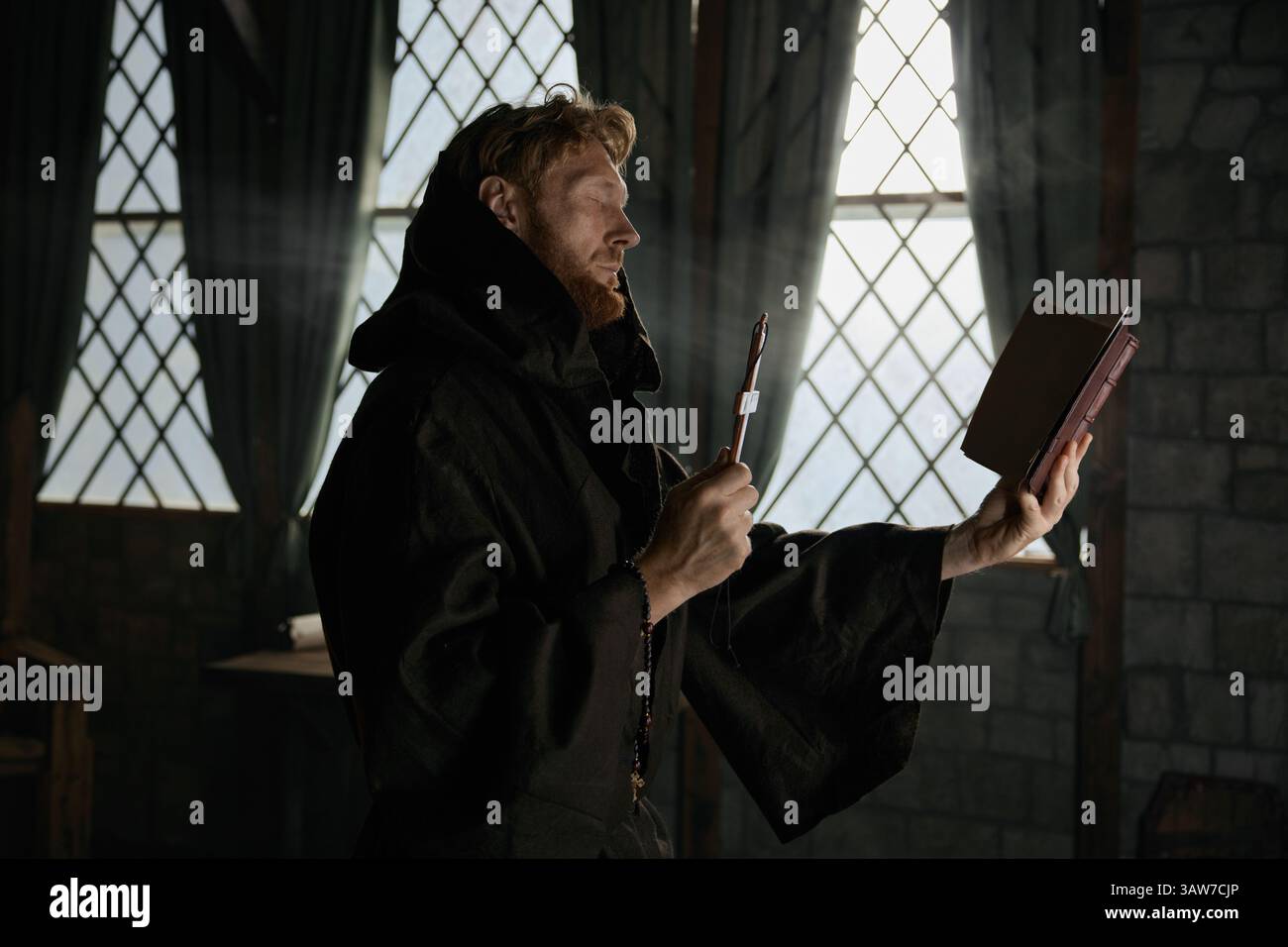Medieval priest holding cross and holy bible performing exorcism rite ...