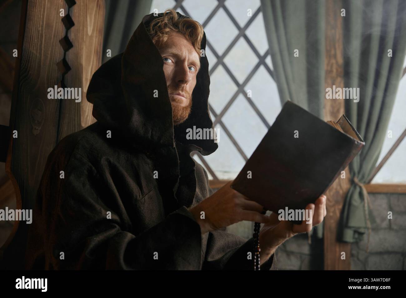 Old medieval monk reading sacred religious book praying with rosary ...