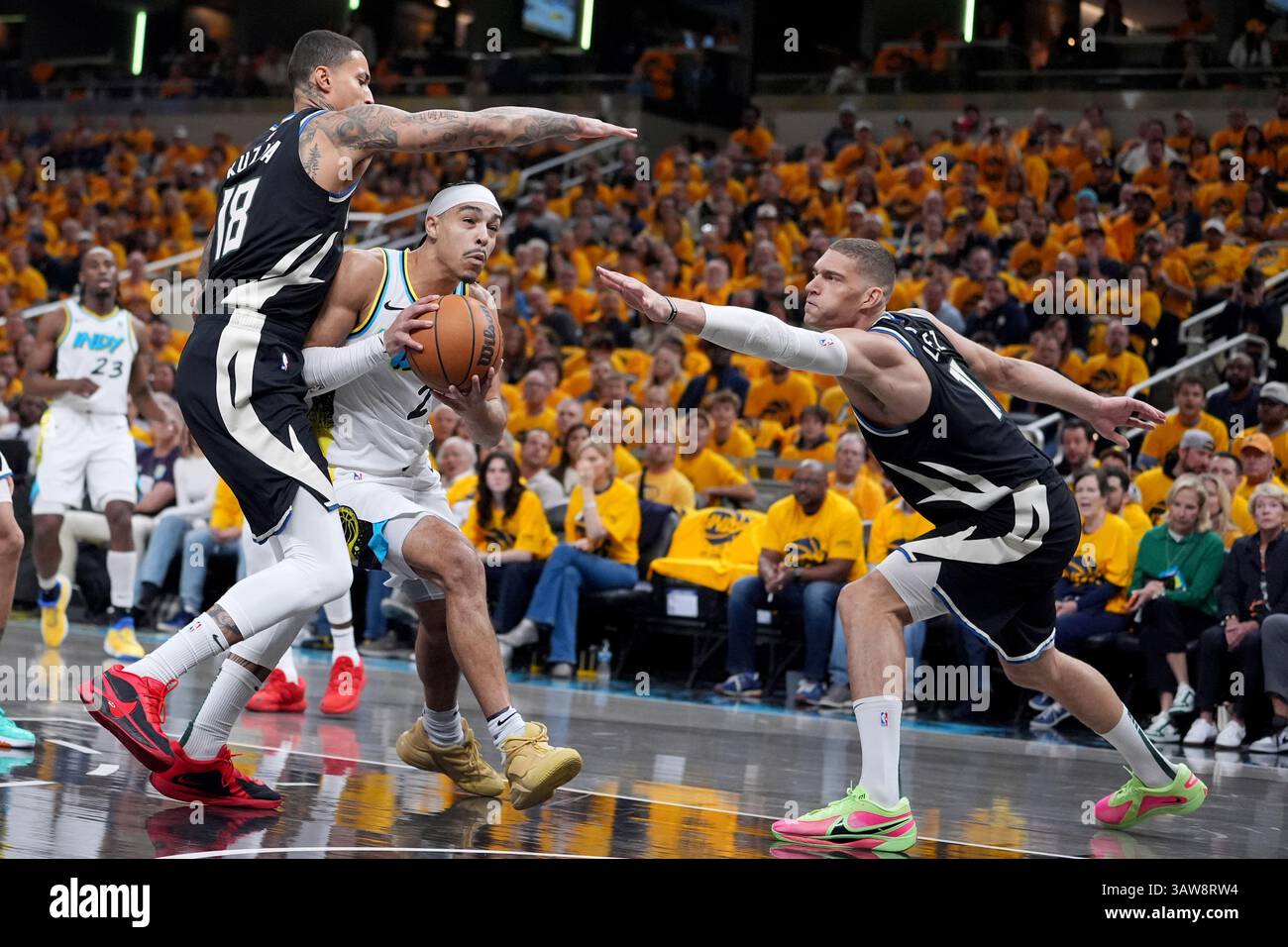 Indiana Pacers' Andrew Nembhard, center, heads to the basket past ...