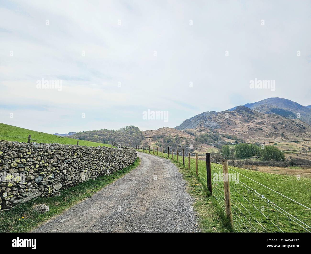 A quiet countryside path runs alongside a traditional dry stone wall ...