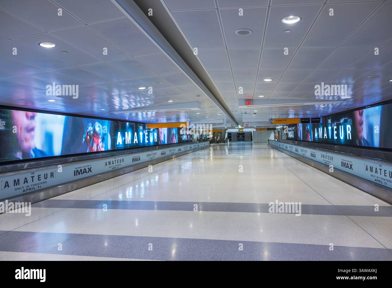 Empty corridor at JFK airport with IMAX movie posters and illuminated ...