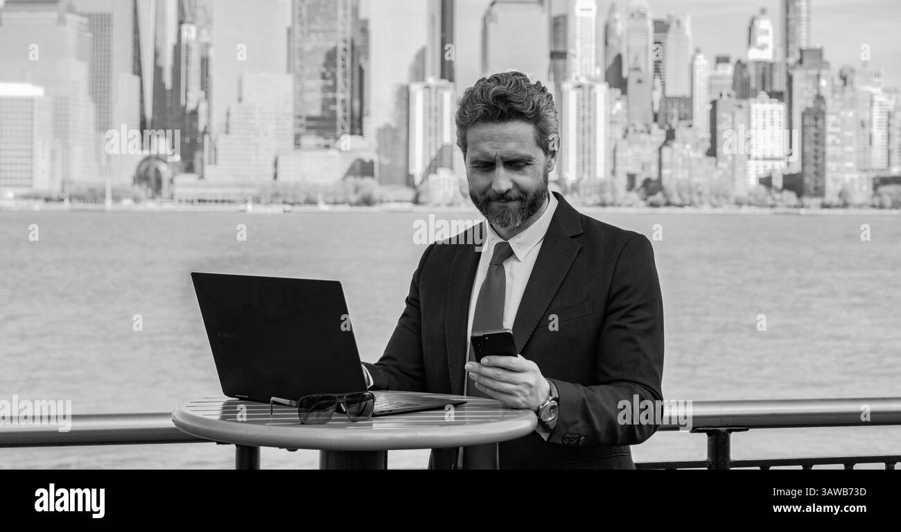 Successful businessman man working and freelancing online with business laptop using phone ...