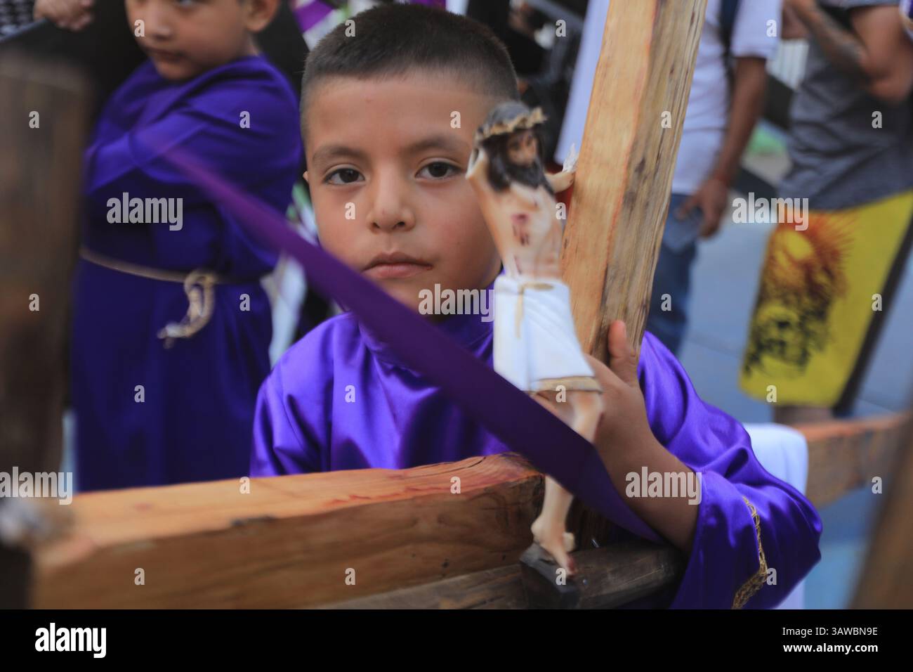 A child carries a cross taking part during the Holy Thursday procession ...