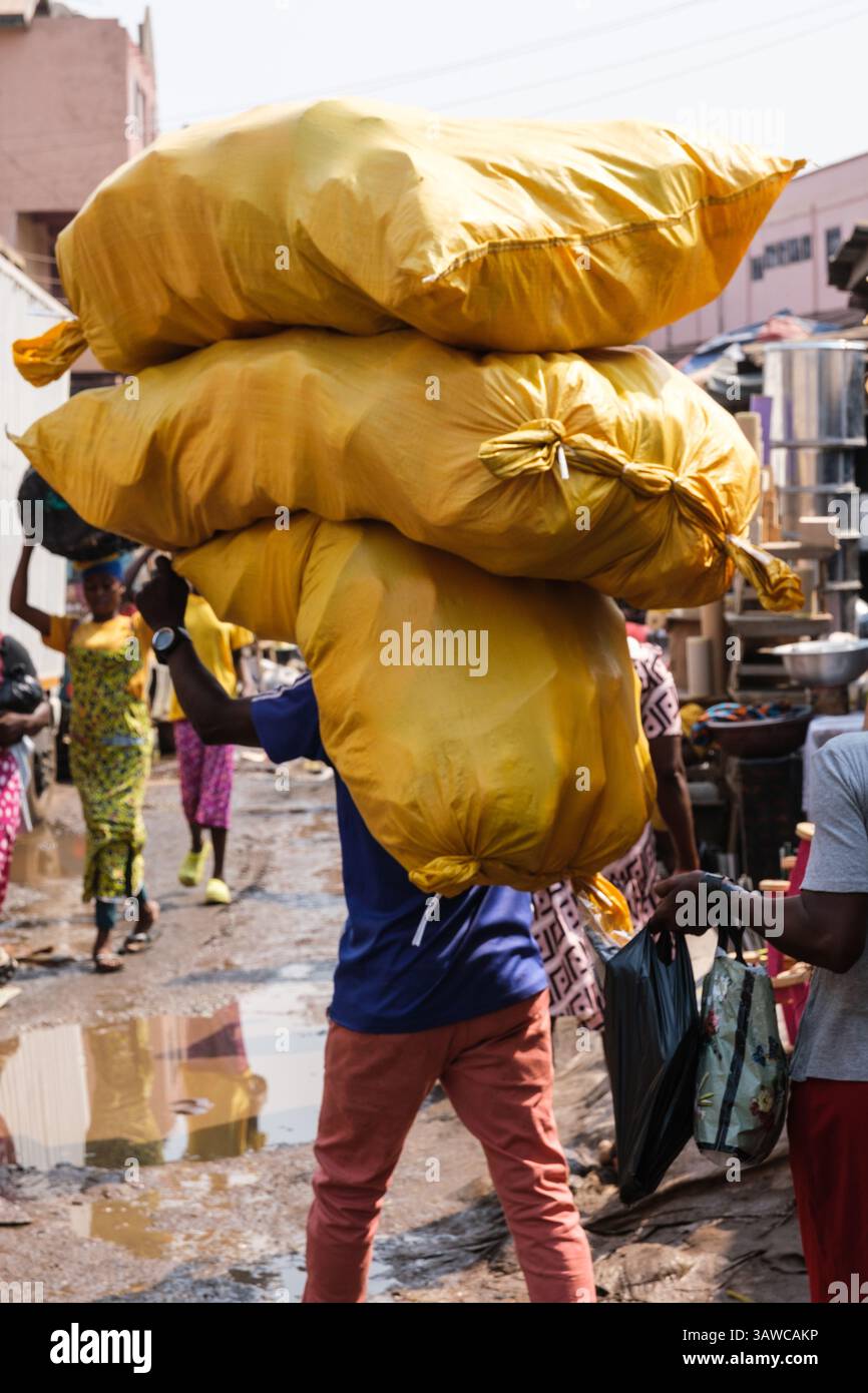 Kumasi, Ghana. Kejetia Market, Man Carrying Gooids on Head and Back ...