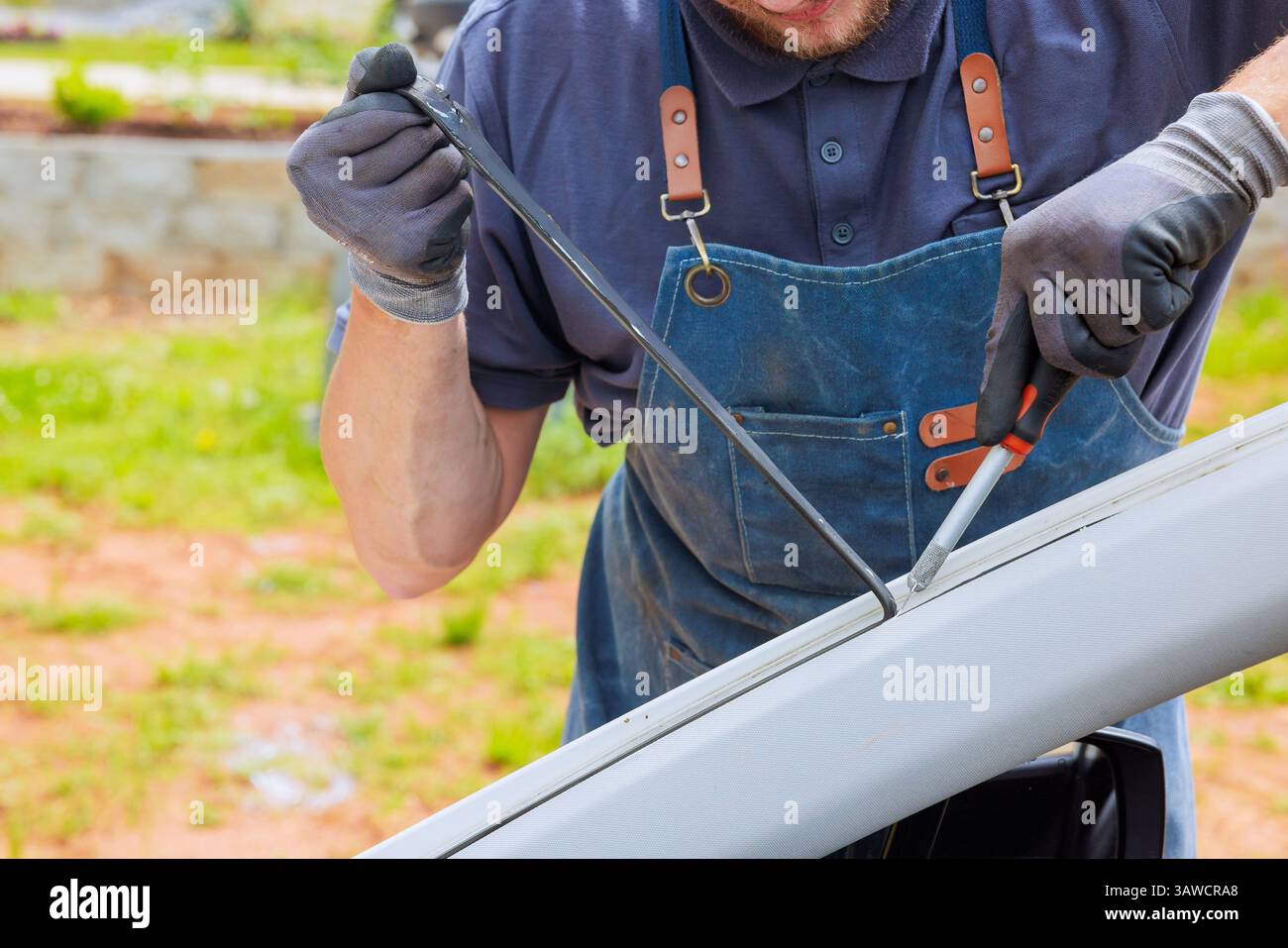 Mechanic work removes damaged silicone sealant on car body in during ...