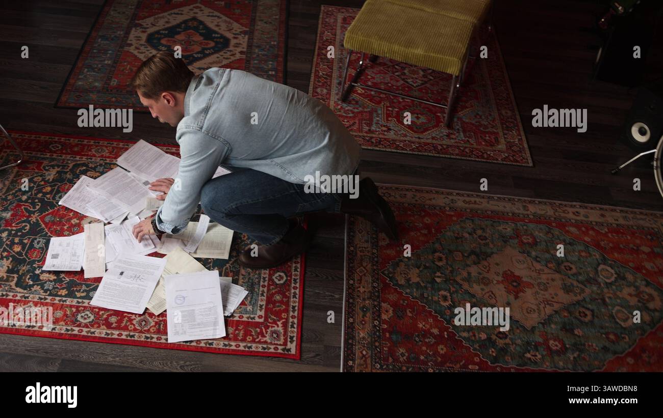 Journalist examines documents on floor, cinematic image of man ...