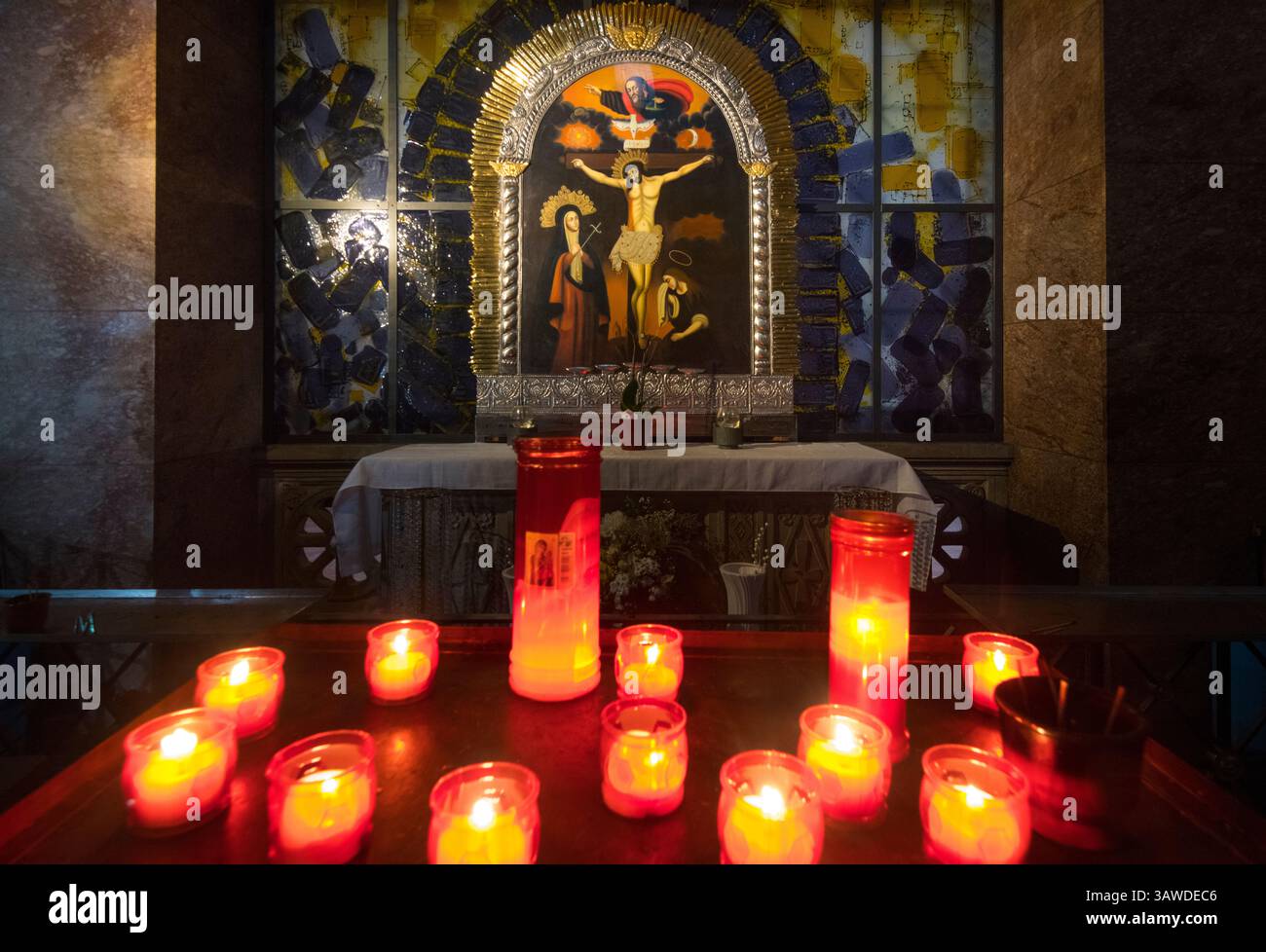Altar with lit candles and a painting of Crucifixion in background. in ...