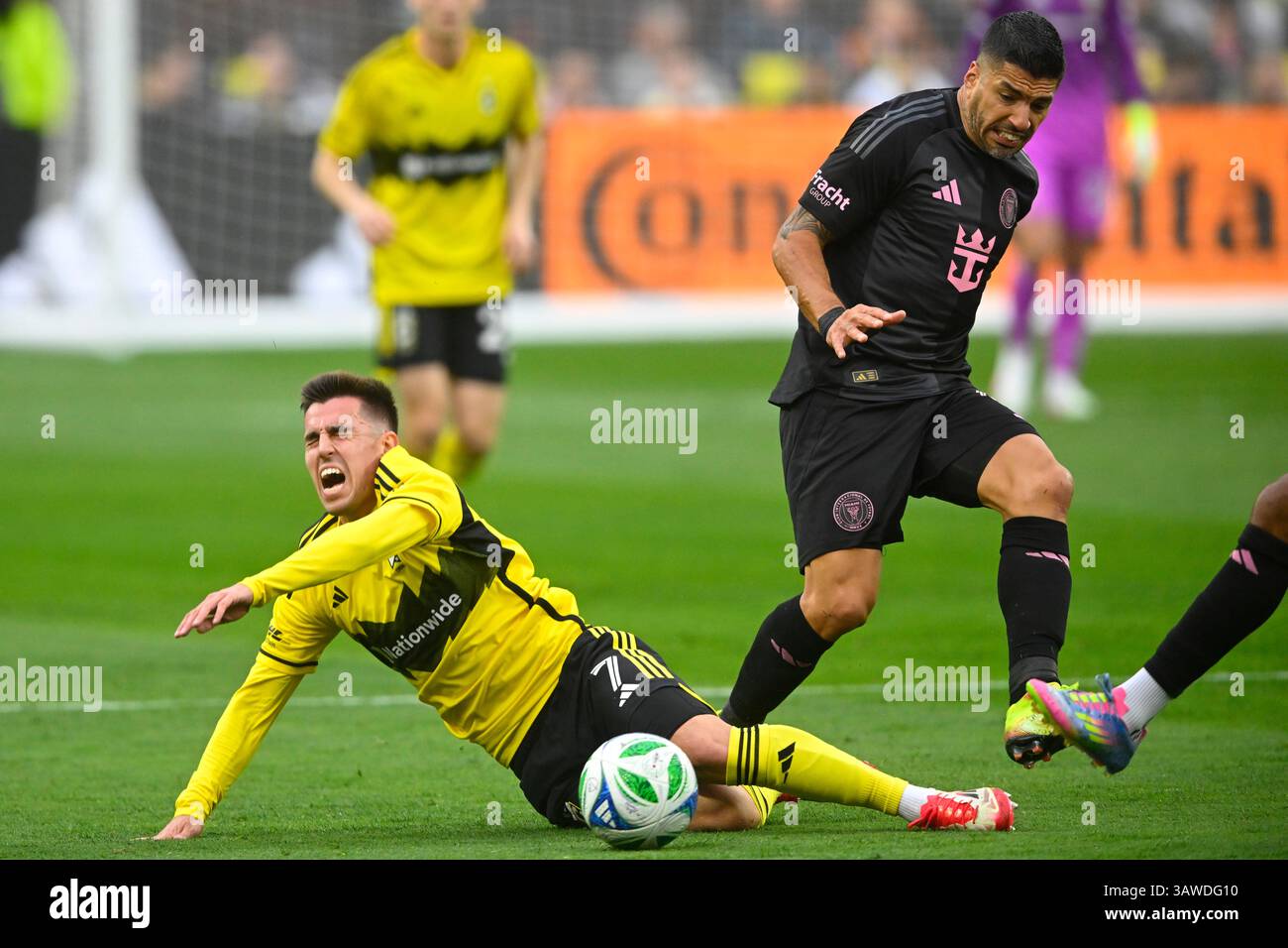 Columbus Crew midfielder Dylan Chambost, left, falls while defended by ...
