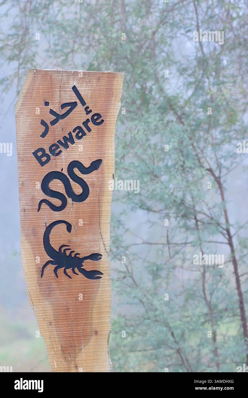 A weathered wooden warning sign prominently stating "Beware" in both ...