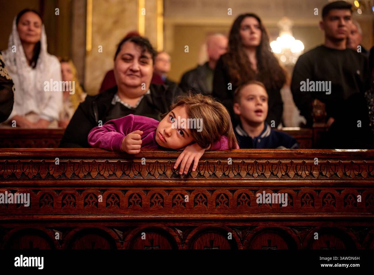 A child rests her head on a pew frontal during the Orthodox Easter ...