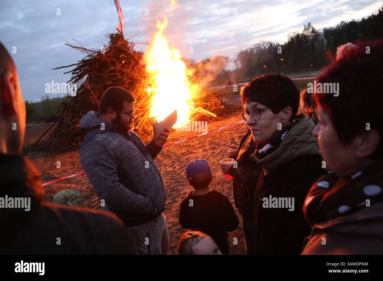 April 19, 2025, Cottbus, Brandenburg, Germany: Visitors look to the Easter fire at Branitzer ...