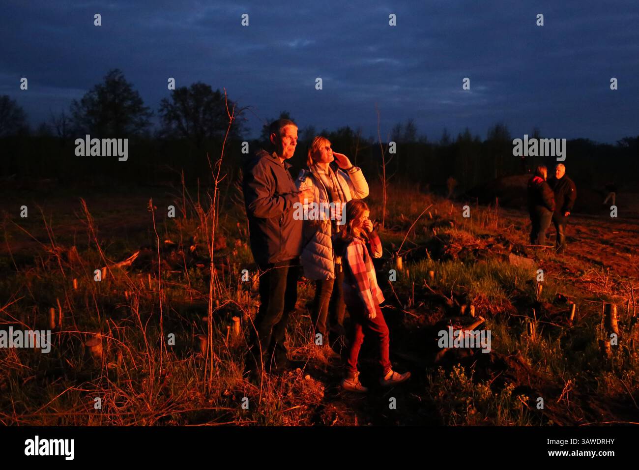 April 19, 2025, Cottbus, Brandenburg, Germany: Visitors look to the Easter fire at Branitzer ...