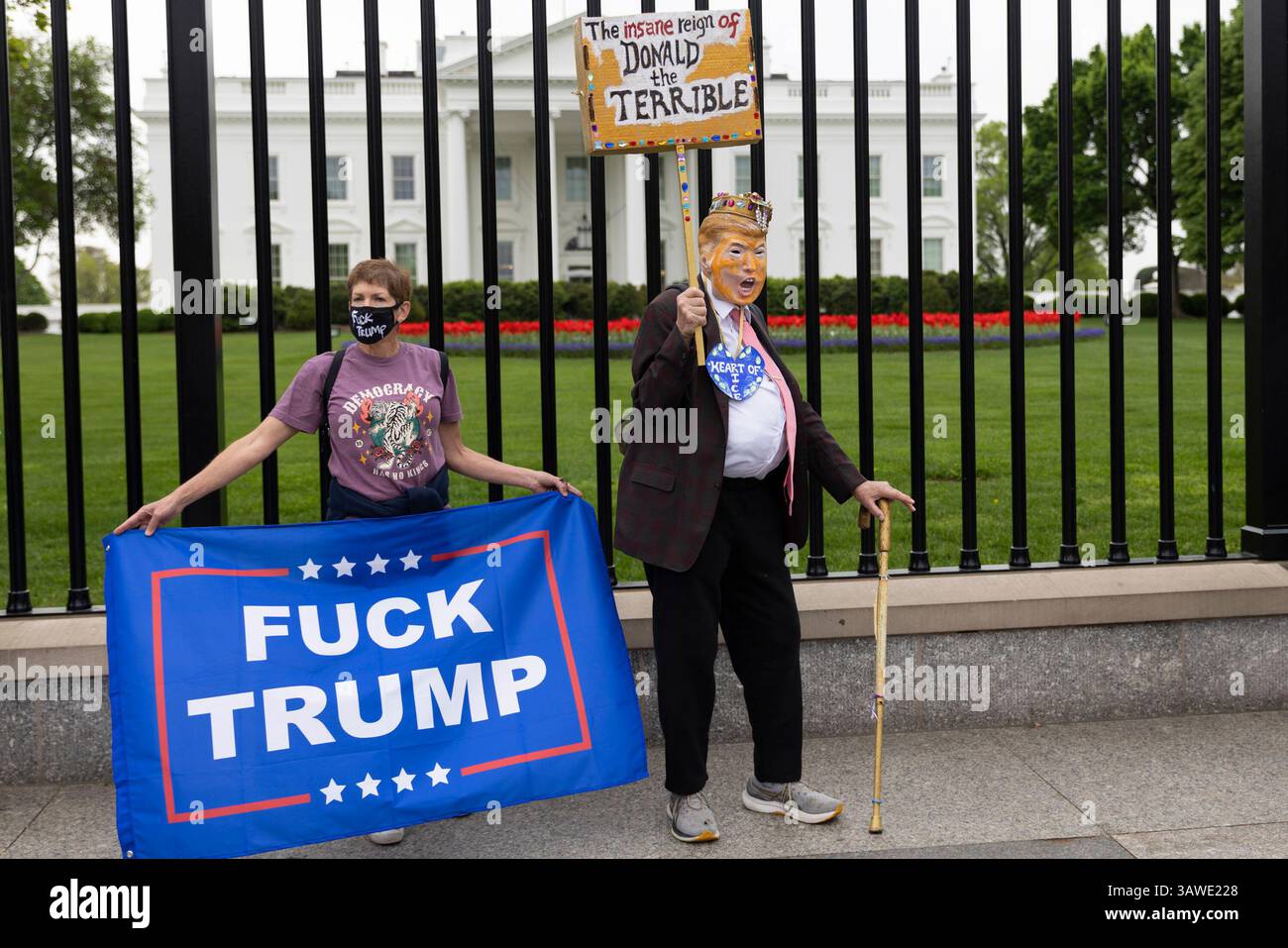 Demonstrators in the anti-Trump protest hold signs on April 19, 2025 ...