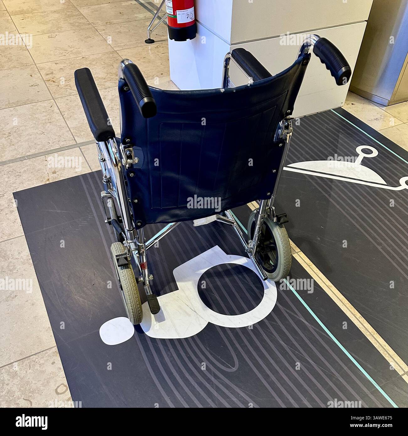 A wheelchair on a designated spot at an airport Stock Photo - Alamy