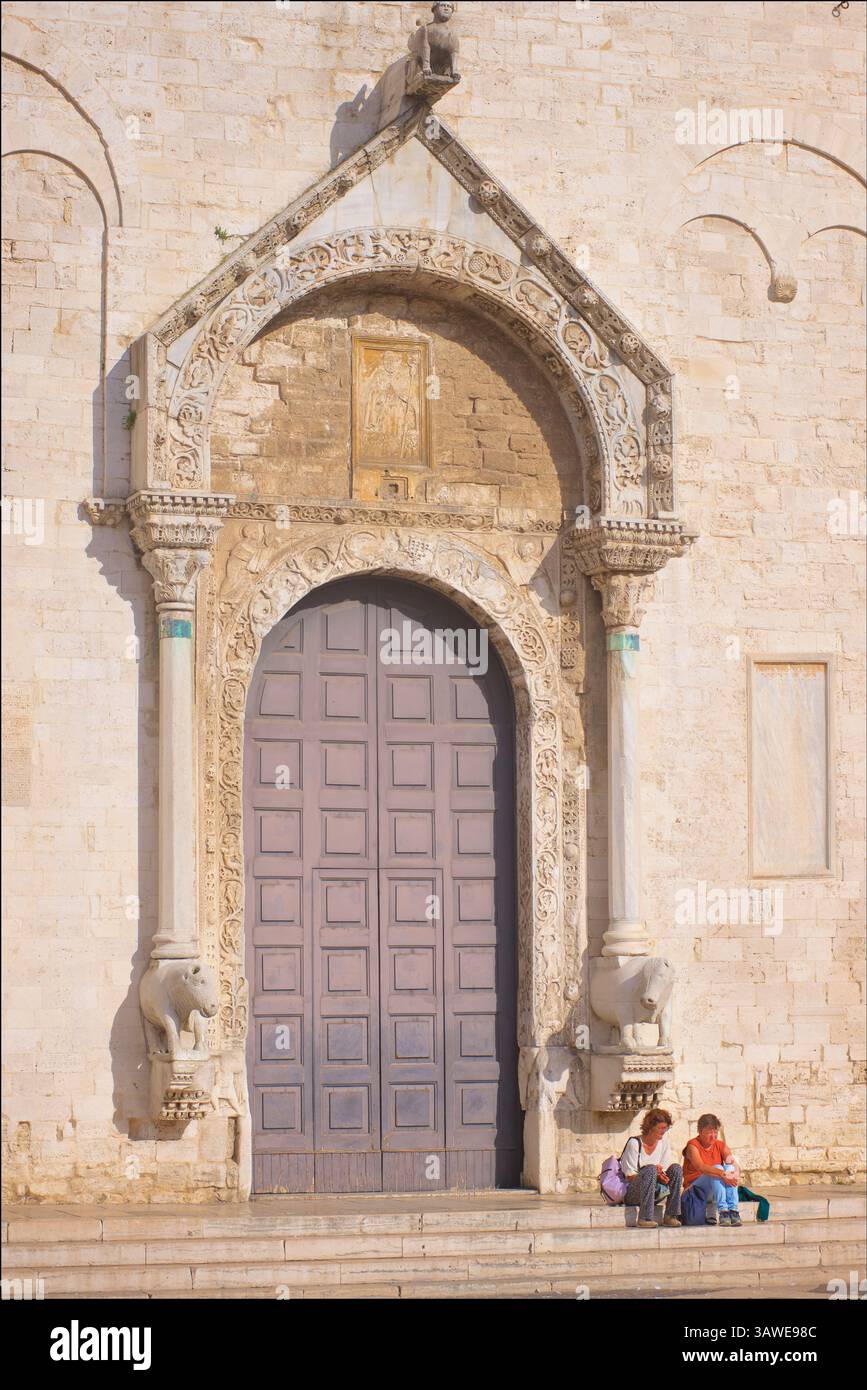 Tourist couple sitting on the steps outside the The Pontifical Basilica ...