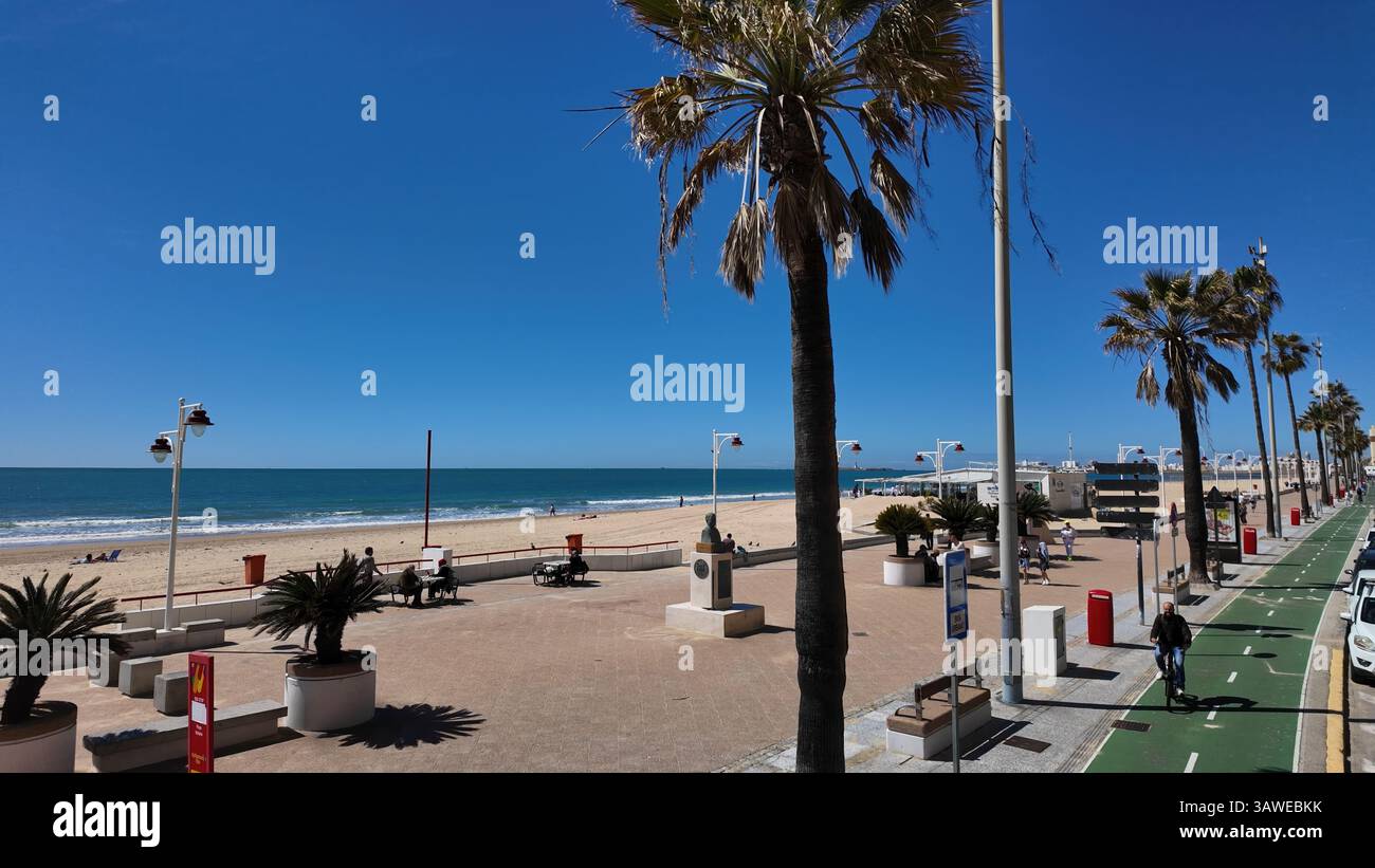 Scenic view of Cadiz beachfront featuring ocean waves, palm trees, bike ...