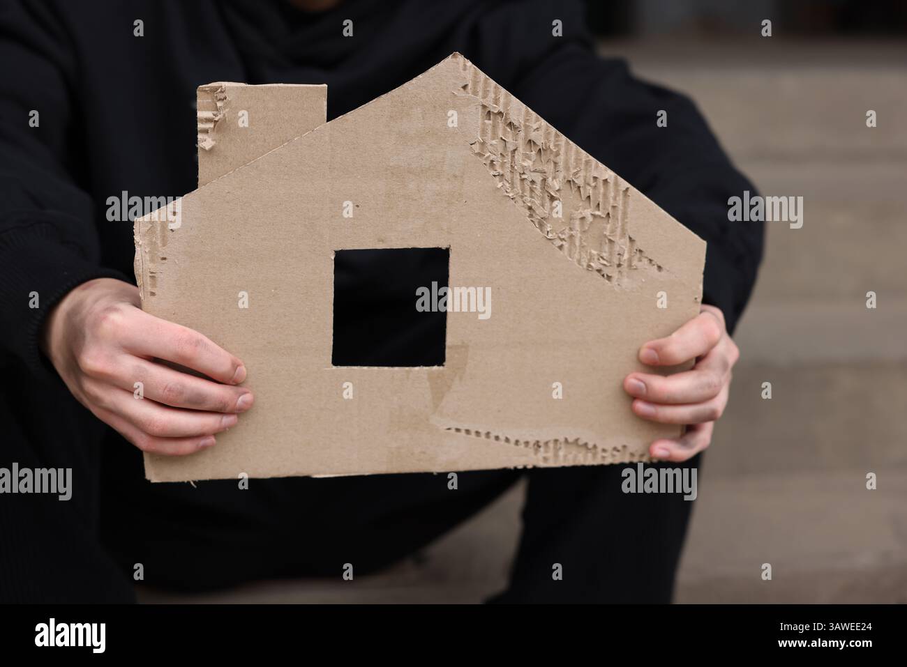 Homeless man with carton house figure outdoors, closeup Stock Photo - Alamy