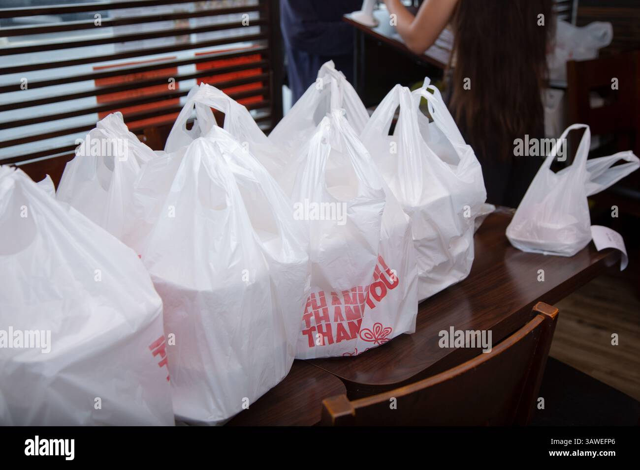A view of several thank you plastic bag to go orders, on display at a ...