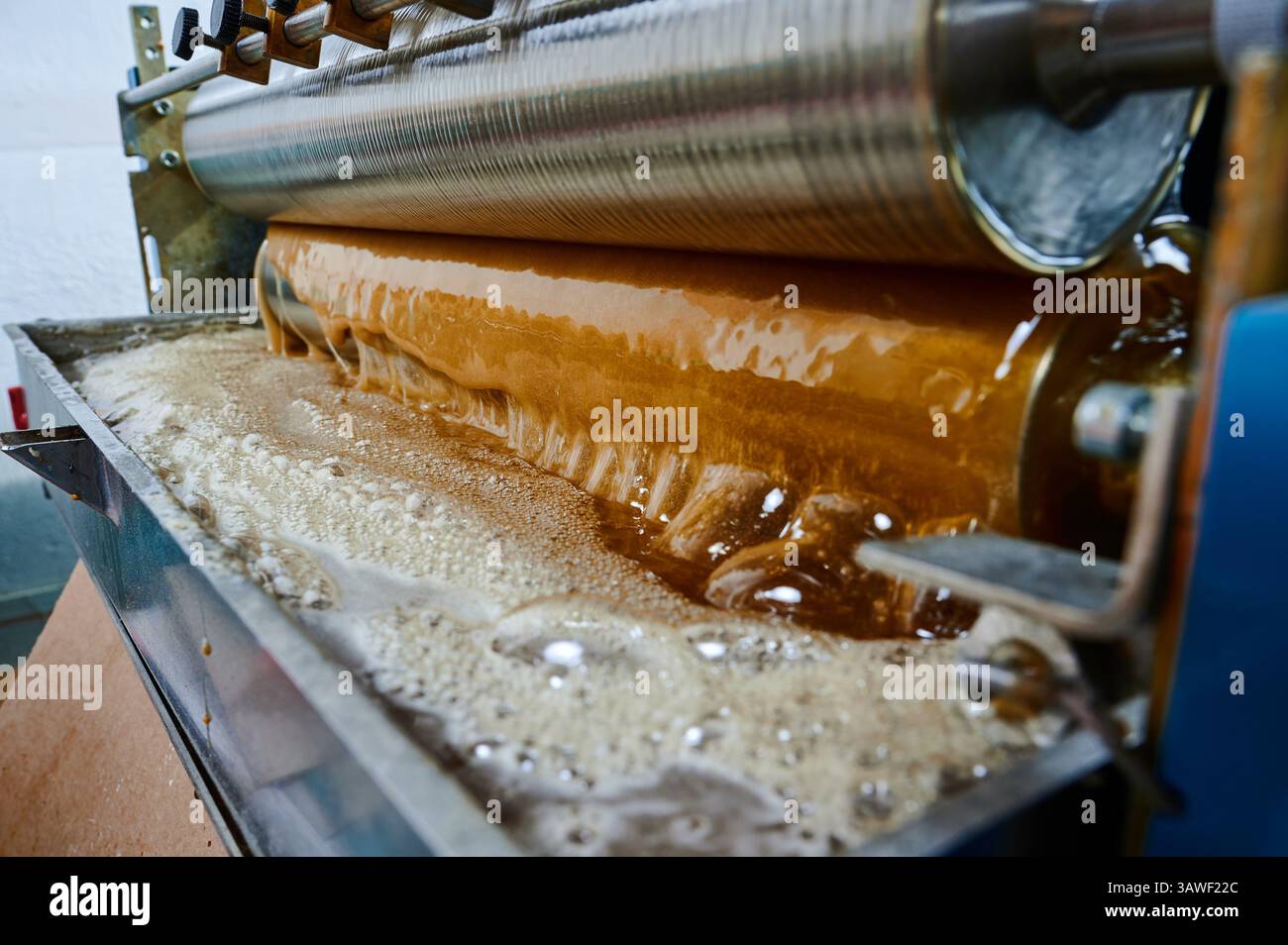 Innovative glue-spreading machine in action featuring a bath for bottom ...