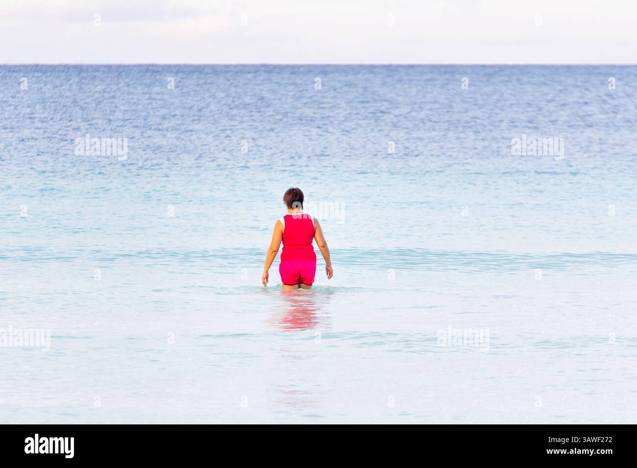 A middle-aged Filipino woman wearing a fuchsia top and pink shorts ...