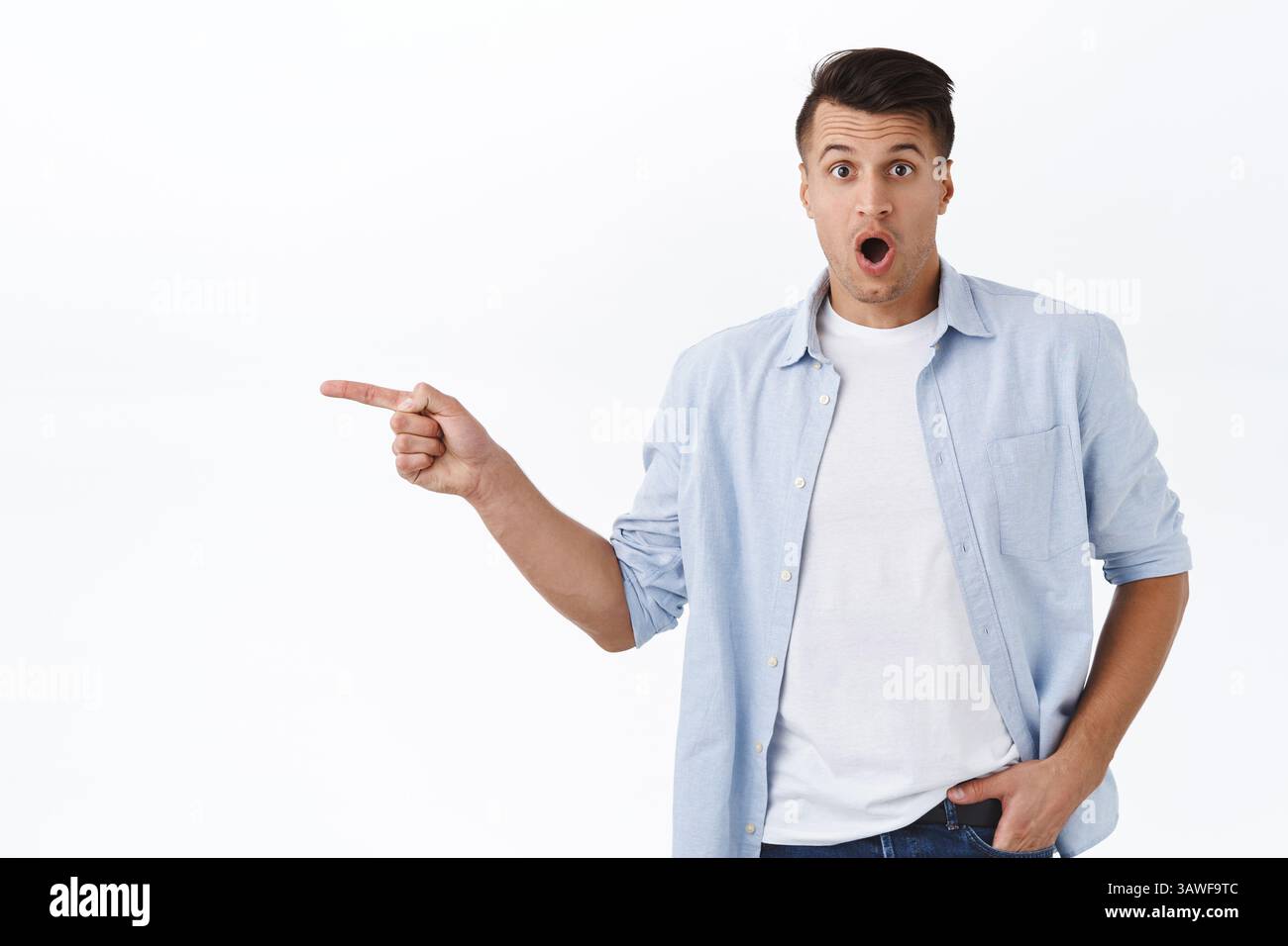 Excited and impressed handsome caucasian man pointing finger left ...