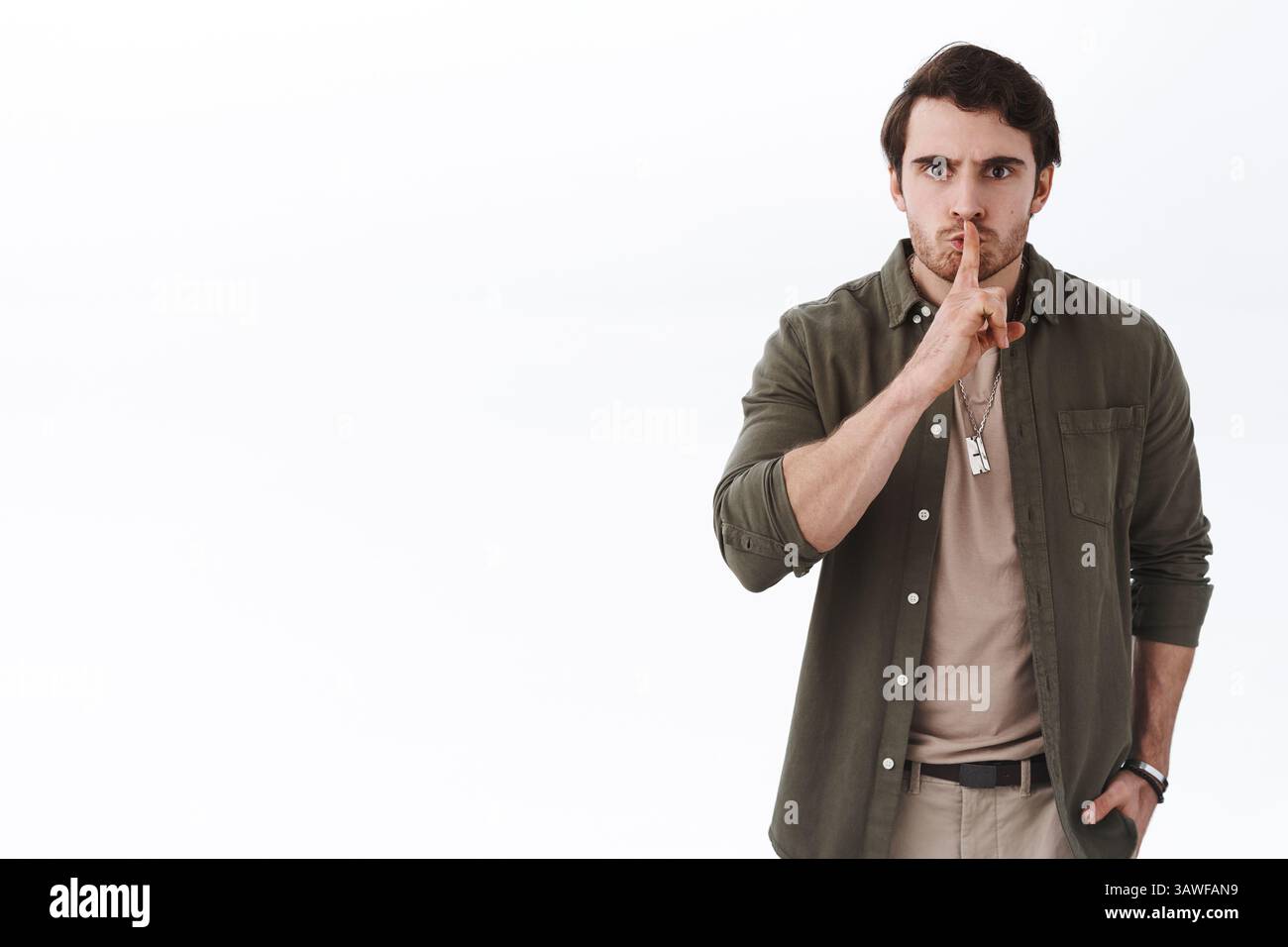 Angry handsome and annoyed male shushing, frowning displeased, cant ...
