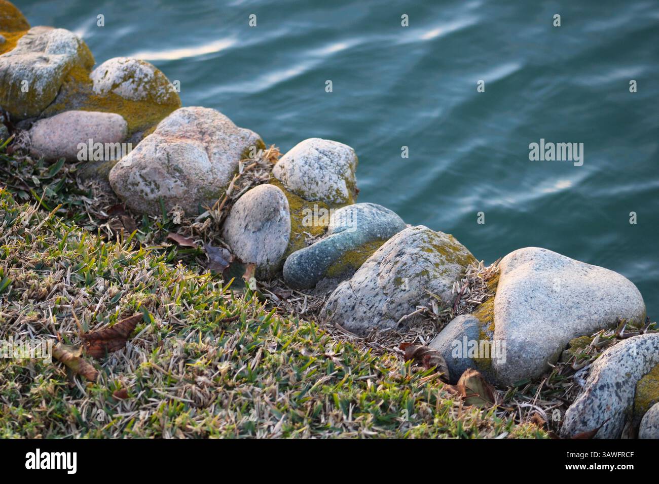 line of gray rocks along the waterside Stock Photo - Alamy