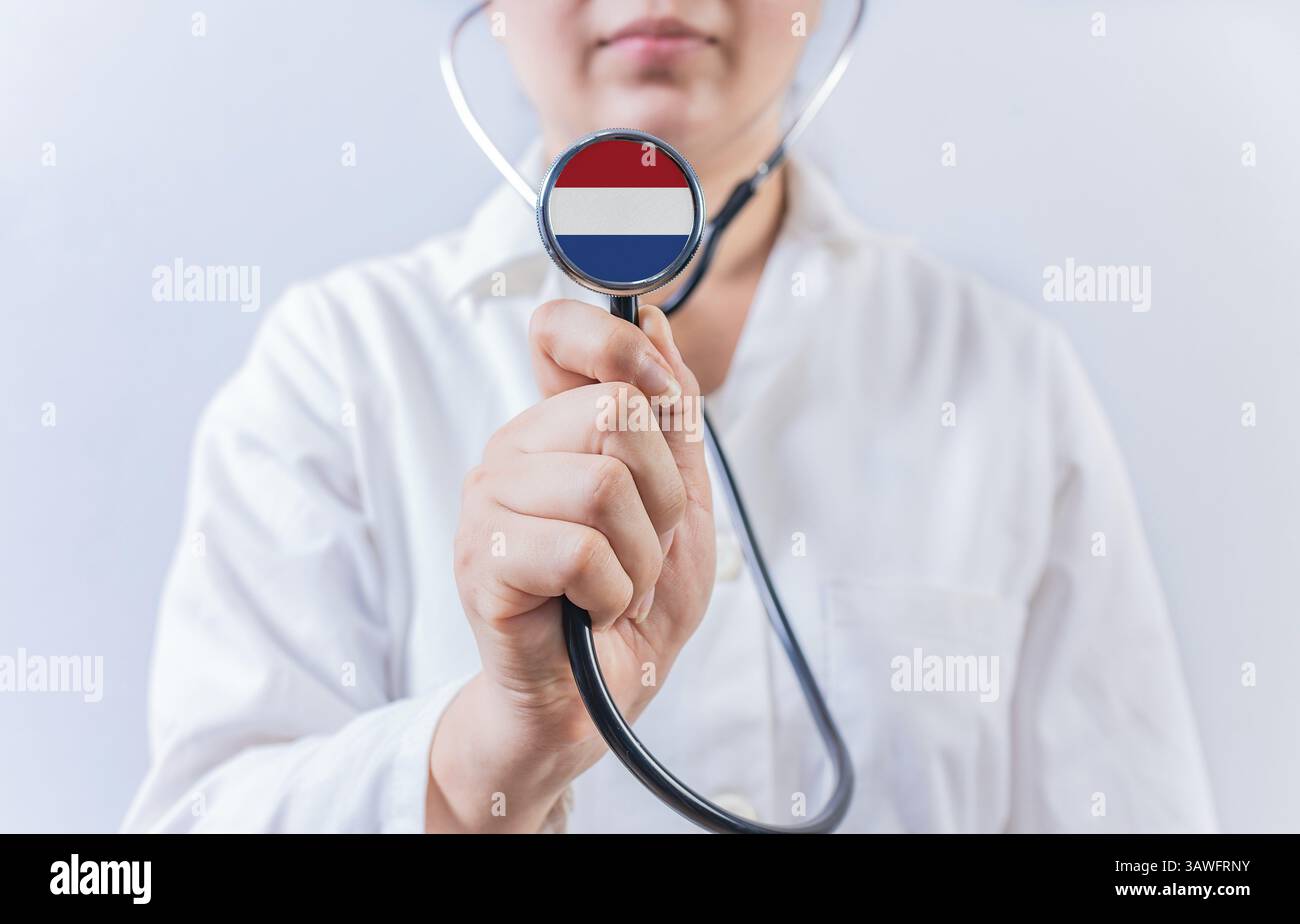 Female doctor holding stethoscope with Dutch flag. National health ...
