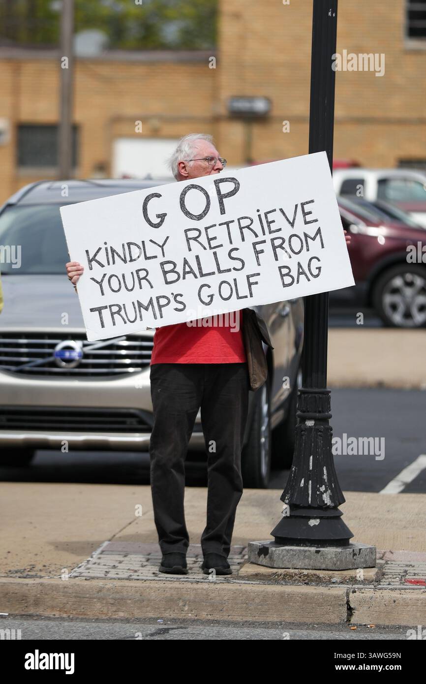 A man holds a placard at a protest against the policies and actions of ...