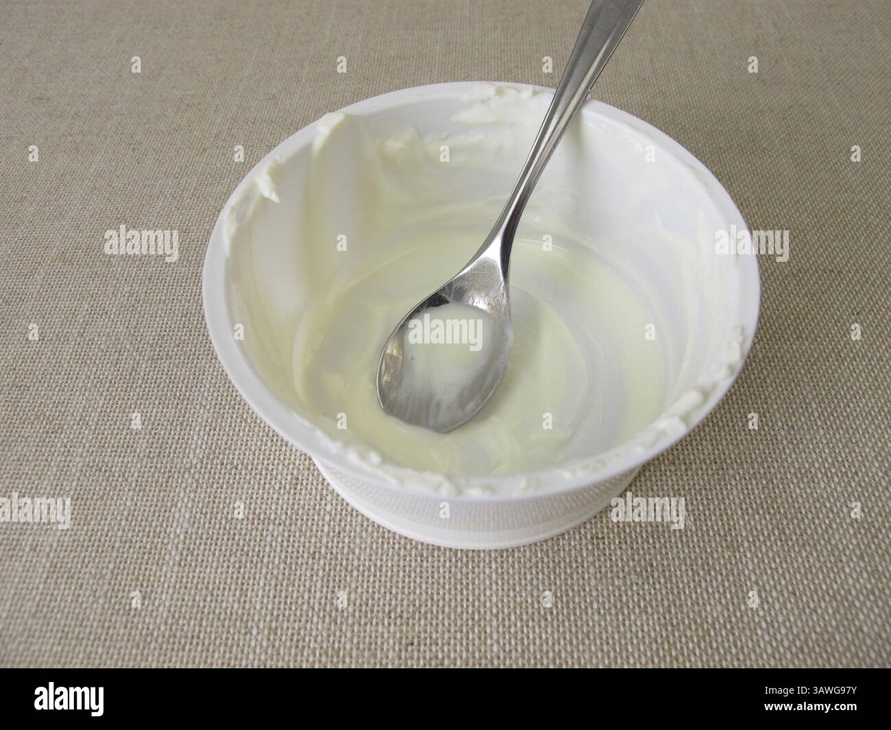 Empty plastic cup with leftover yoghurt and a spoon Stock Photo - Alamy