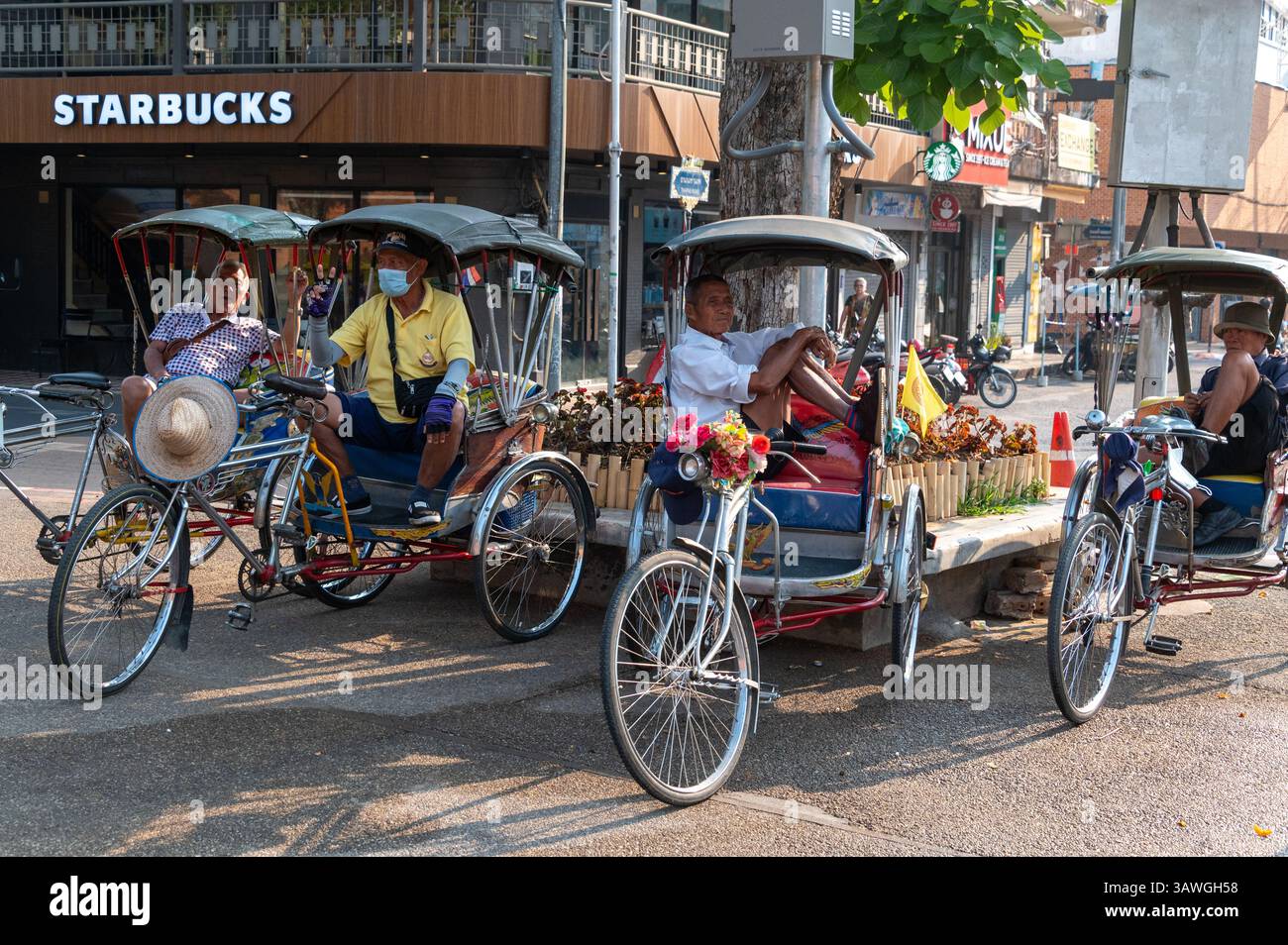 A small group of trishaw cyclists waiting for custom near the old city ...