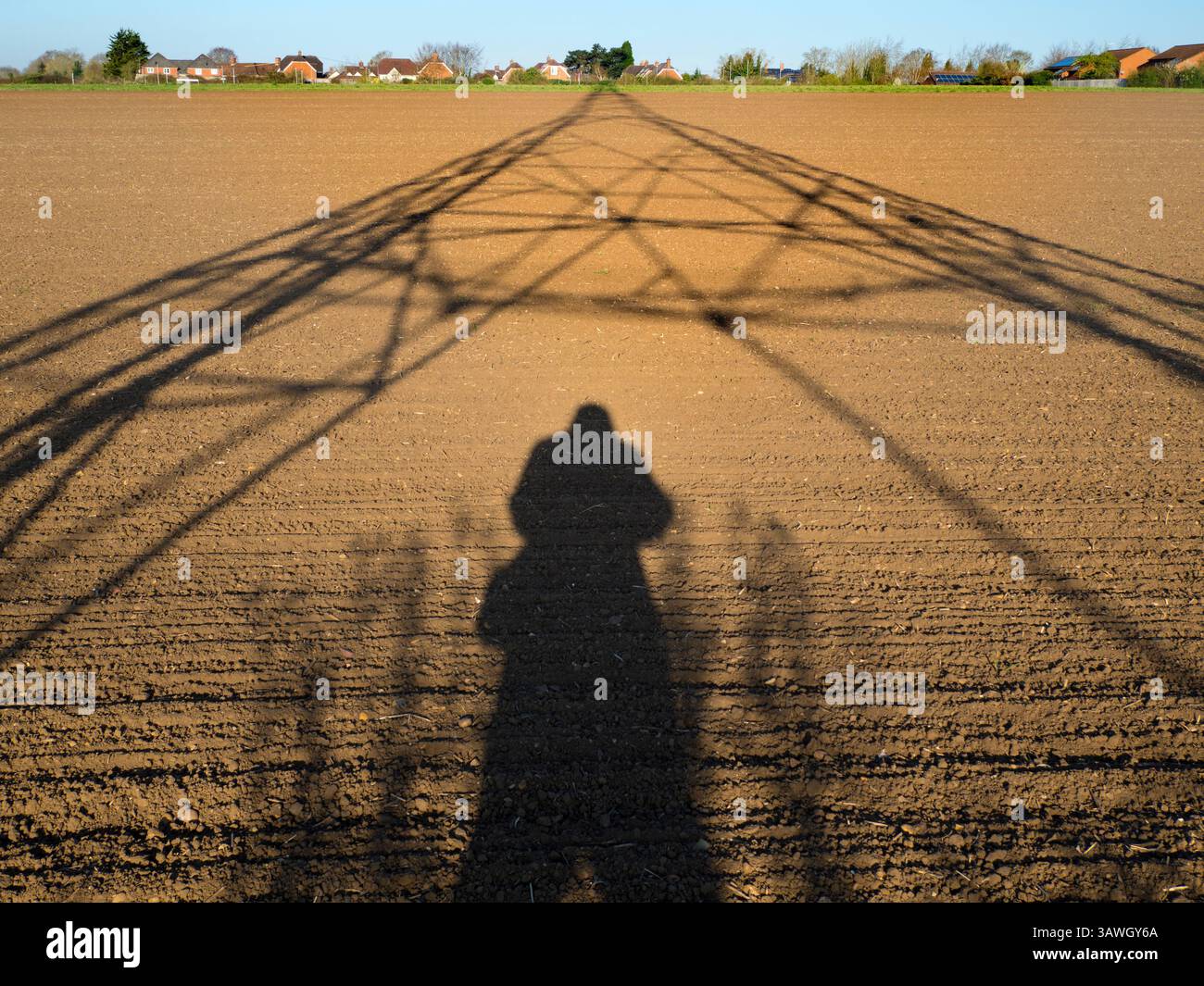 Under the pylon - shadows within shadows. Early shadows in a field in ...