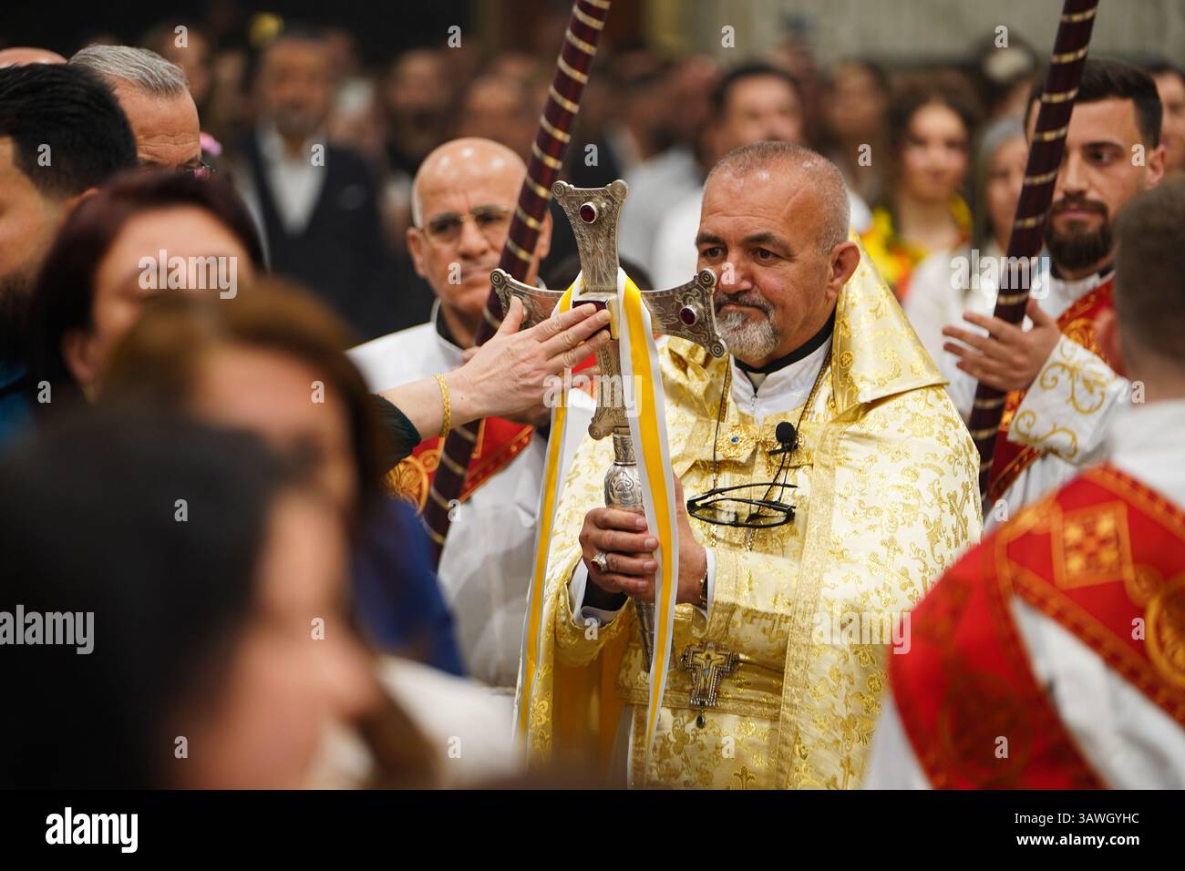 Al Hamdaniya, Iraq. 19th Apr, 2025. A Syriac Catholic priest carries ...