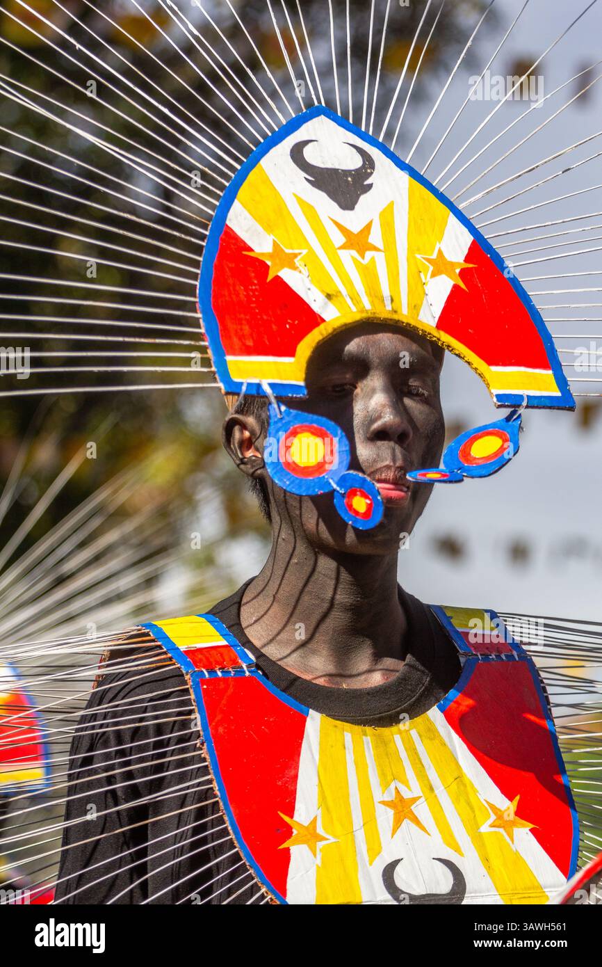 Participant in black face paint to honor the Ati tribe and wearing ...