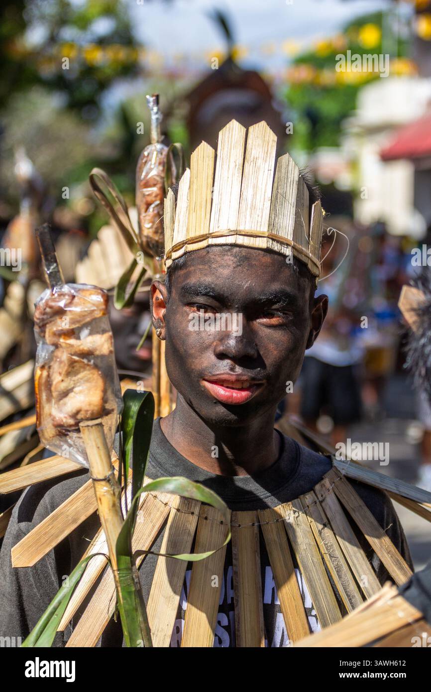 Participant in black face paint to honor the Ati tribe and wearing ...