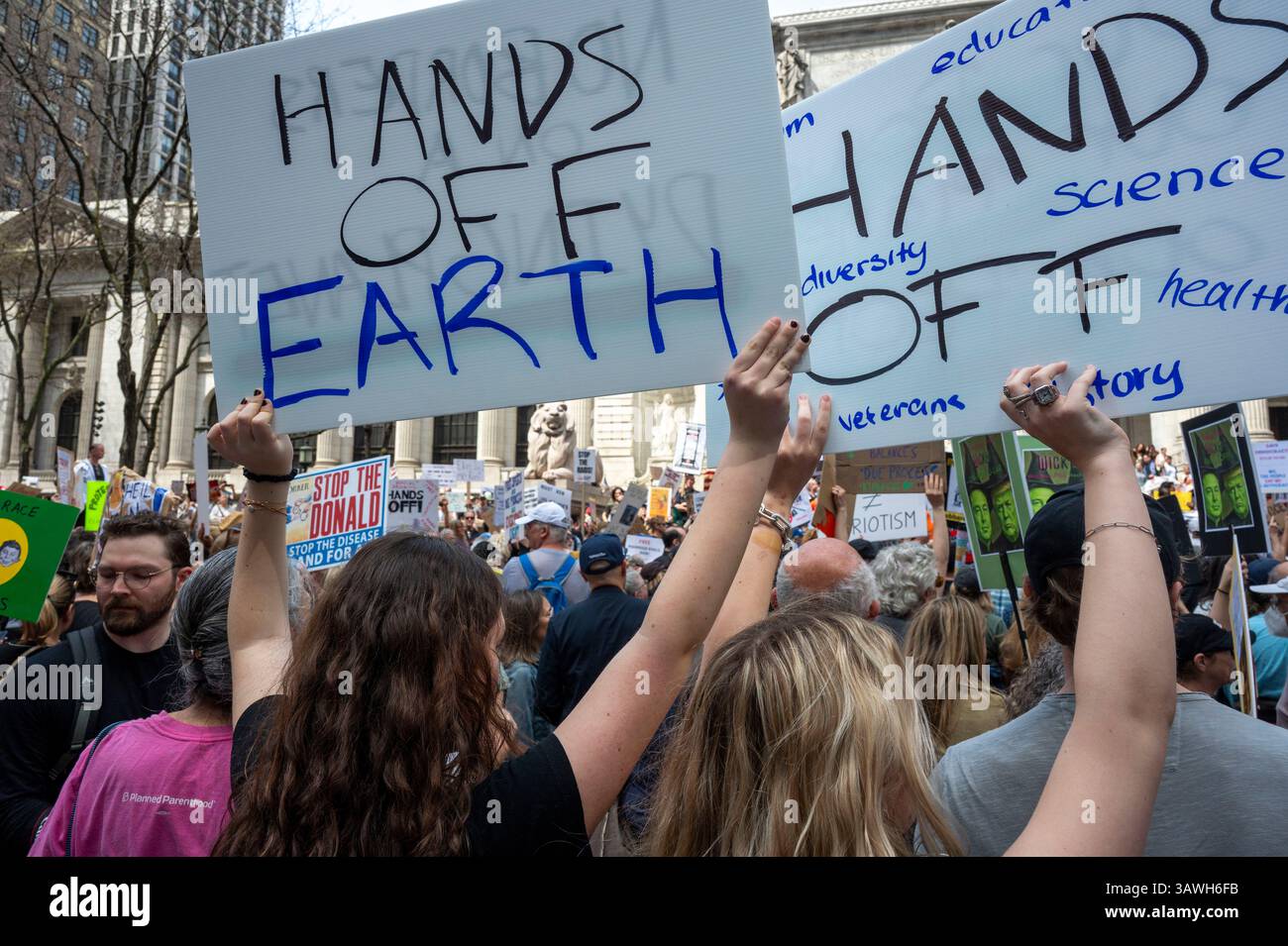 New York, United States. 19th Apr, 2025. A protester holds a "HANDS OFF ...