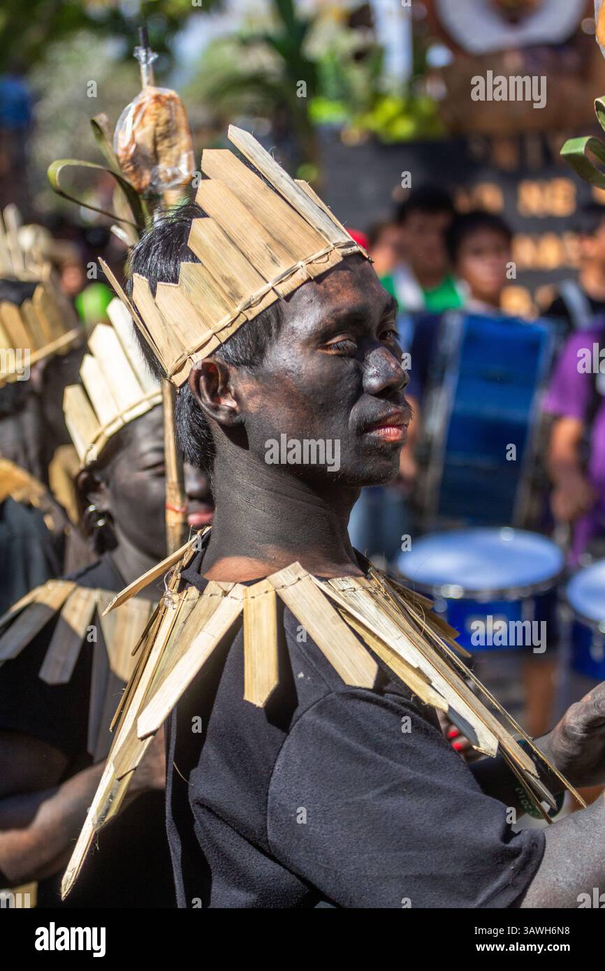 Participant in black face paint to honor the Ati tribe and wearing ...