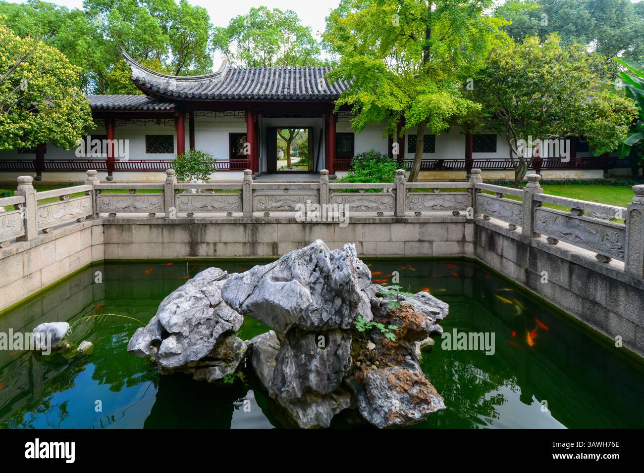 Pond with odd shaped rocks and koi fish inside a Chinese pavilion ...