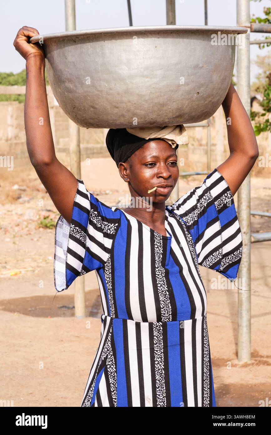 Sonyo, Ghana. Steadying a Full Water Basin before the Walk Home. The ...
