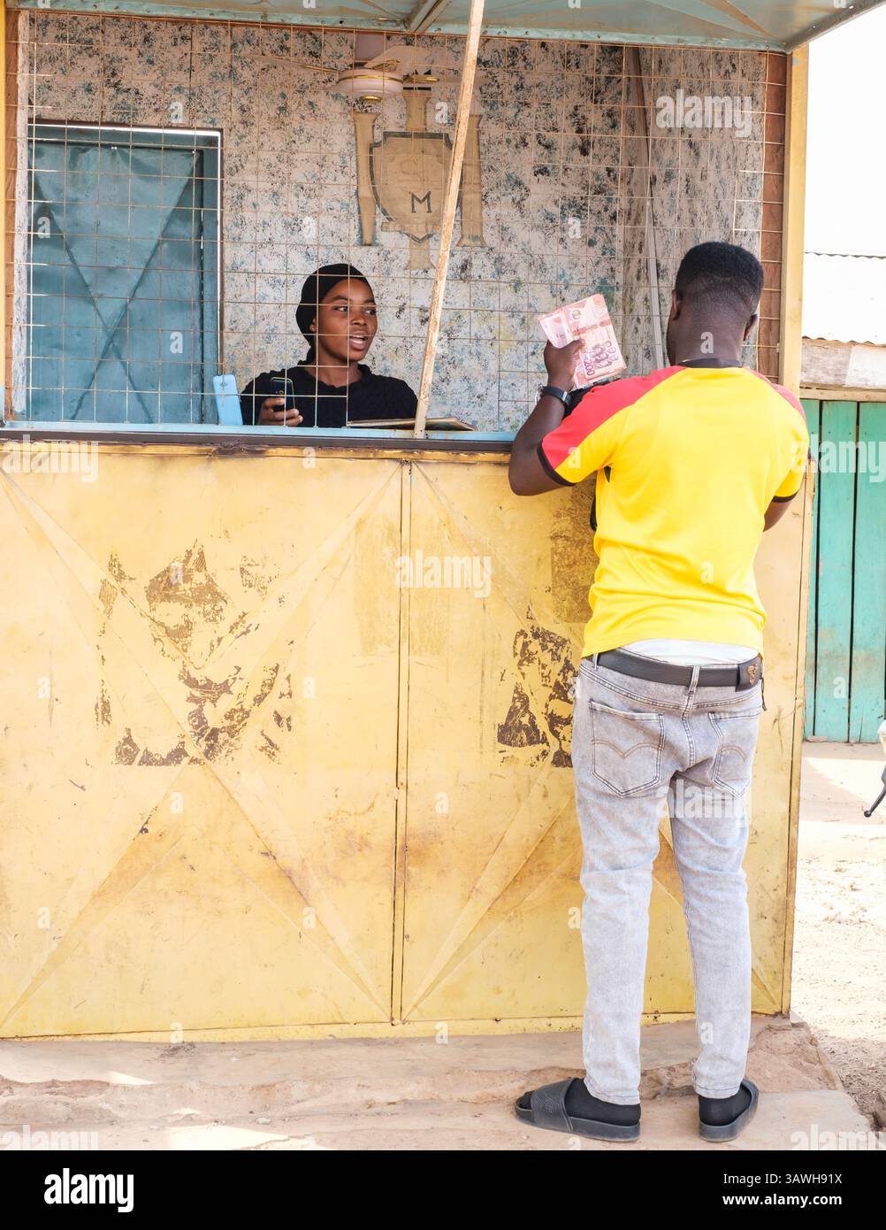 Sonyo, Ghana. Customer Handing Money to Attendant at Mobile Money Kiosk ...