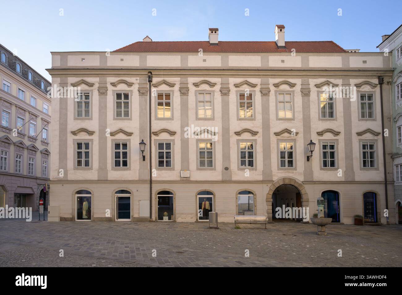 Visitors admire the elegant exterior of Mozarthaus in Linz, Austria ...