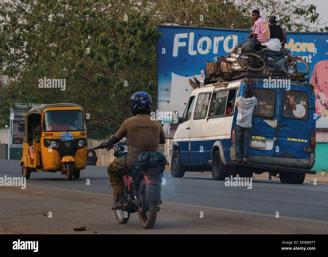Ghana, Tamale. Street Scene. Two Men Riding on Top of Luggage on Top of ...